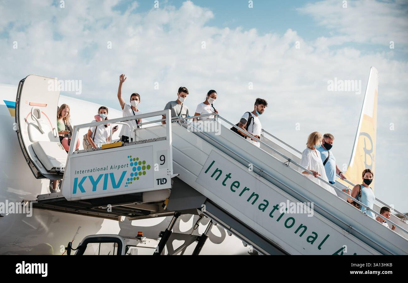 Happy passengers disembarking an airplane. Group of passengers waving ...