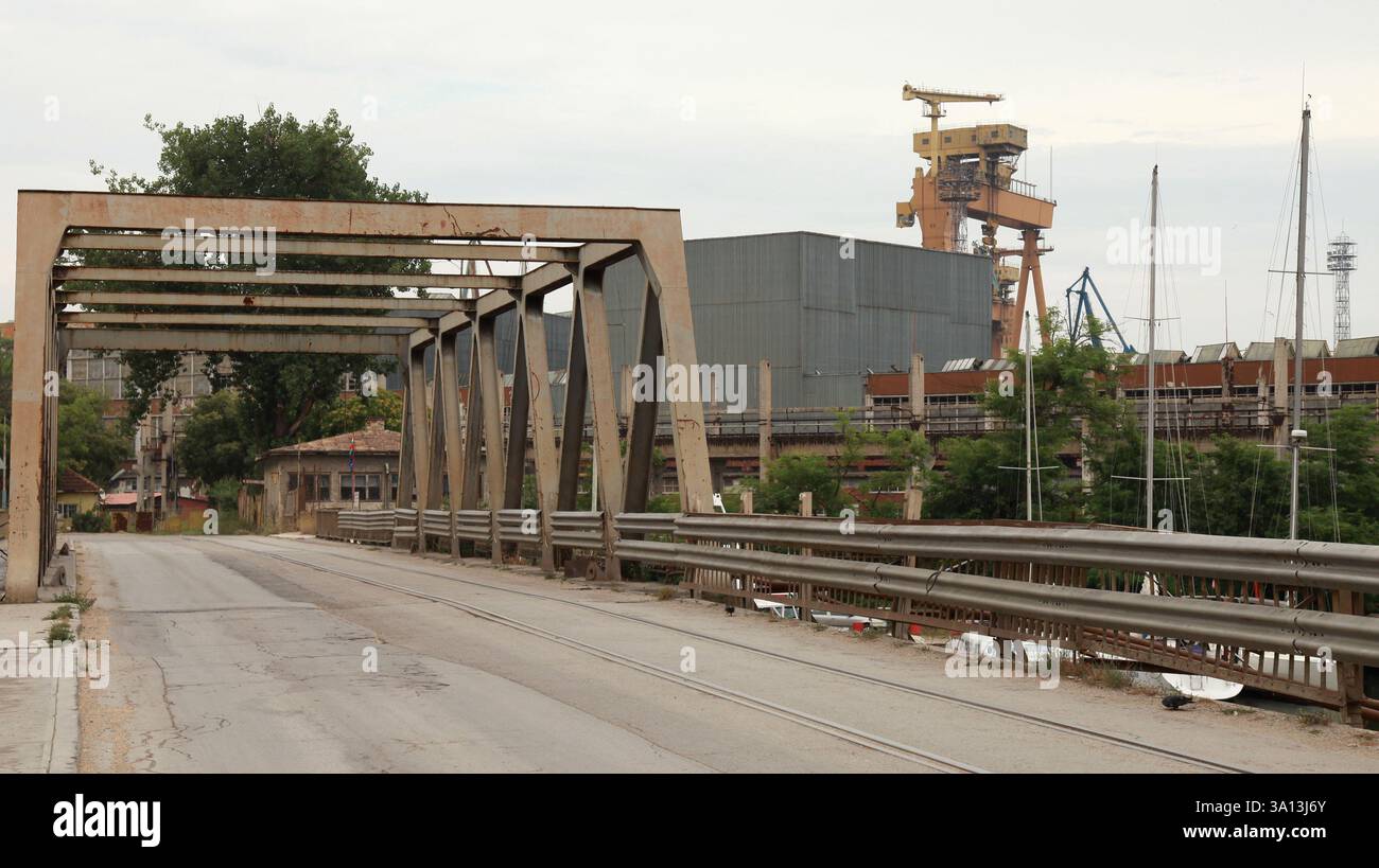 Metal bridge spanning a road near industrial surroundings with ...