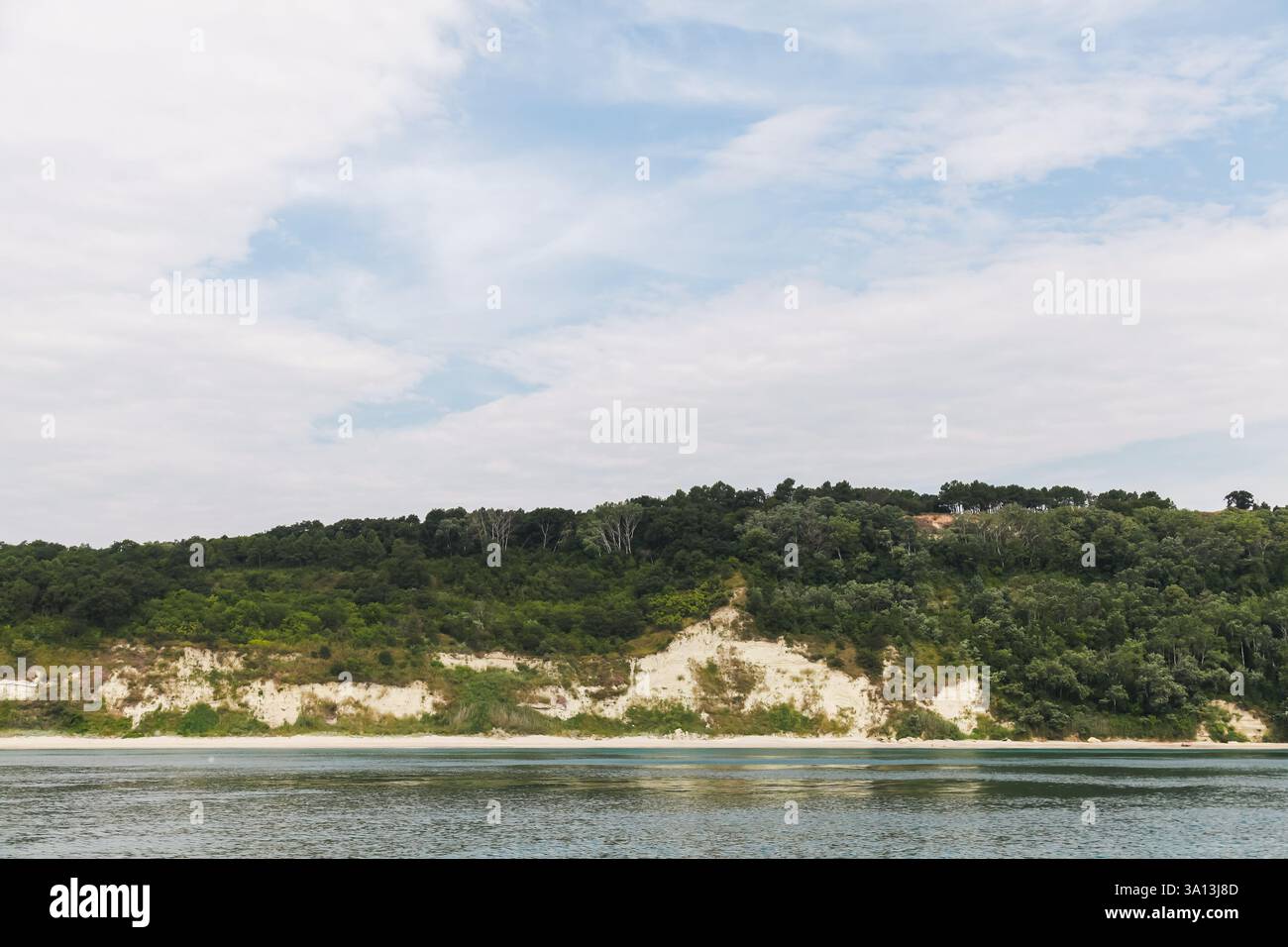 Tranquil nature scenery featuring a lush green hillside with trees, a ...