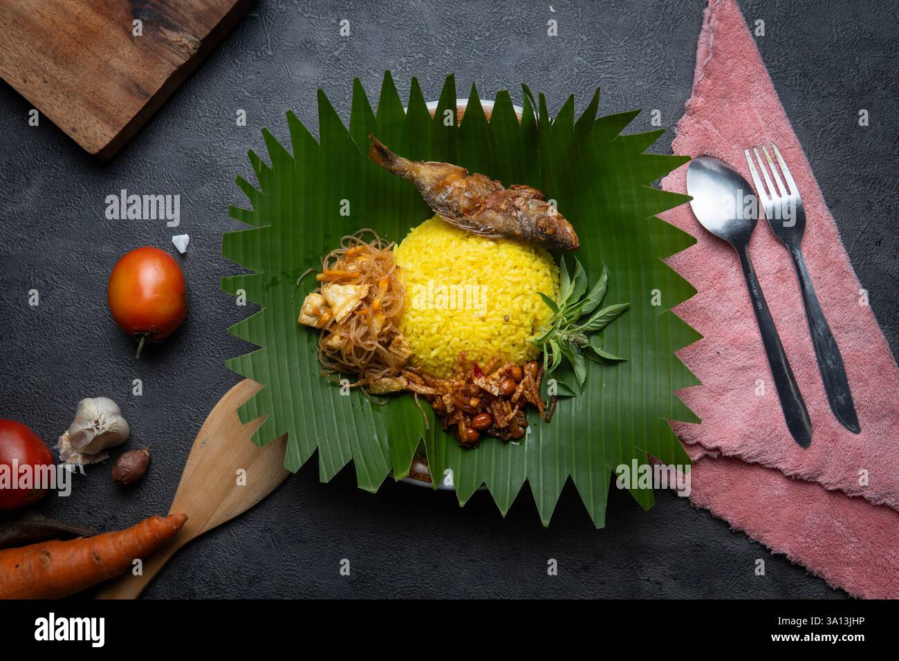 Authentic Indonesian Nasi Kuning served on banana leaves with fried ...