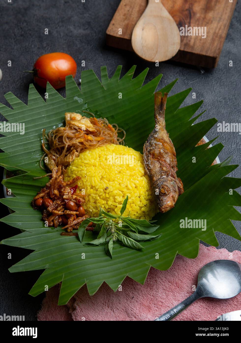 Authentic Indonesian Nasi Kuning served on banana leaves with fried ...