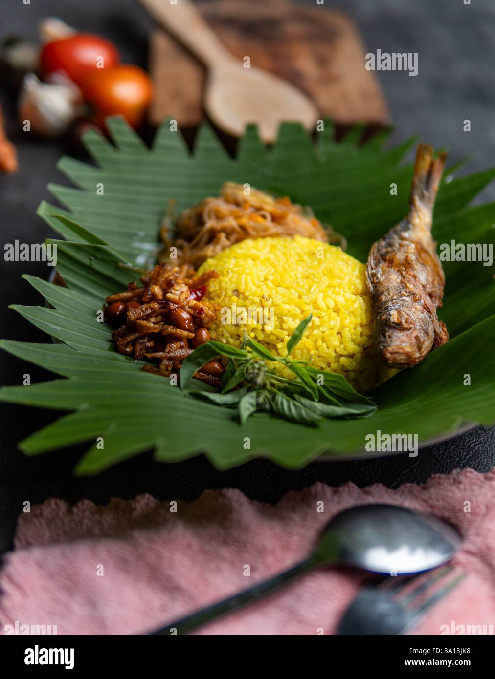 Authentic Indonesian Nasi Kuning served on banana leaves with fried ...
