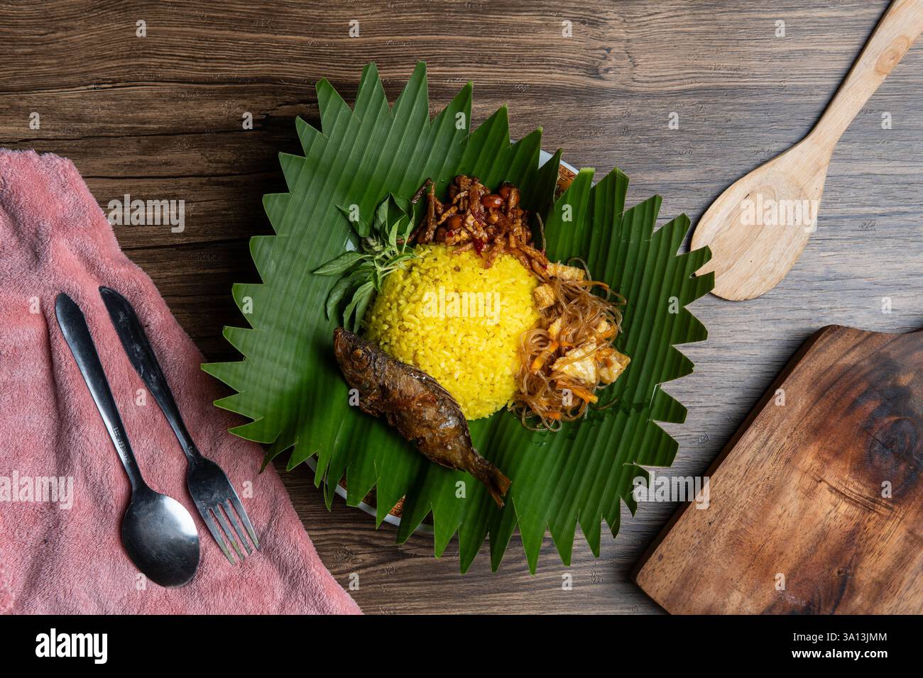 Authentic Indonesian Nasi Kuning served on banana leaves with fried ...