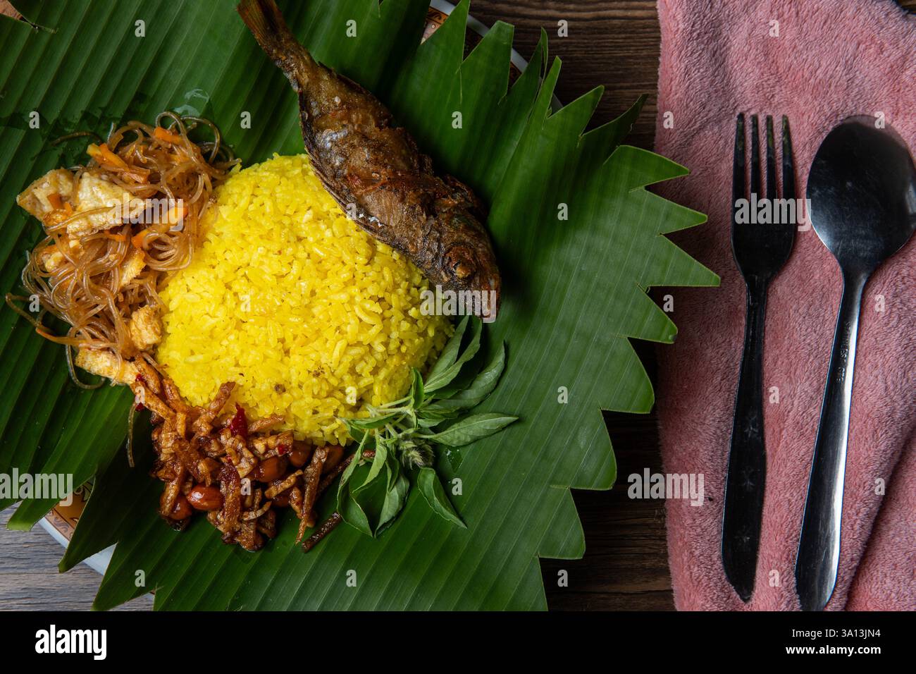 Authentic Indonesian Nasi Kuning served on banana leaves with fried ...