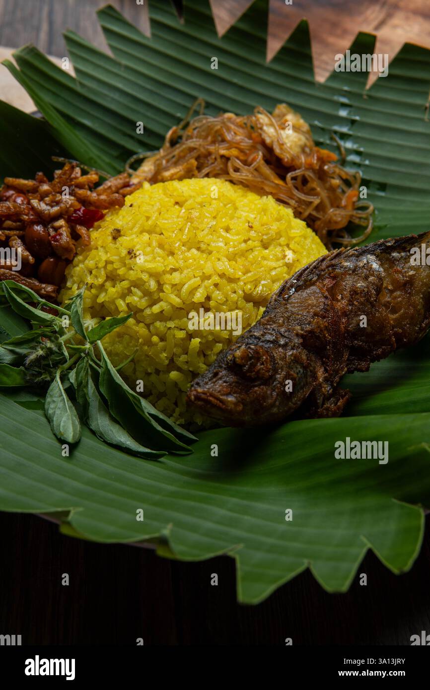 Authentic Indonesian Nasi Kuning served on banana leaves with fried ...