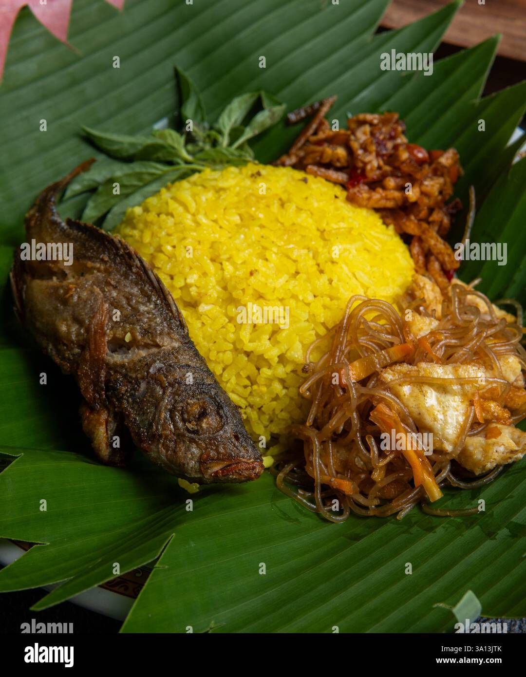 Authentic Indonesian Nasi Kuning served on banana leaves with fried ...