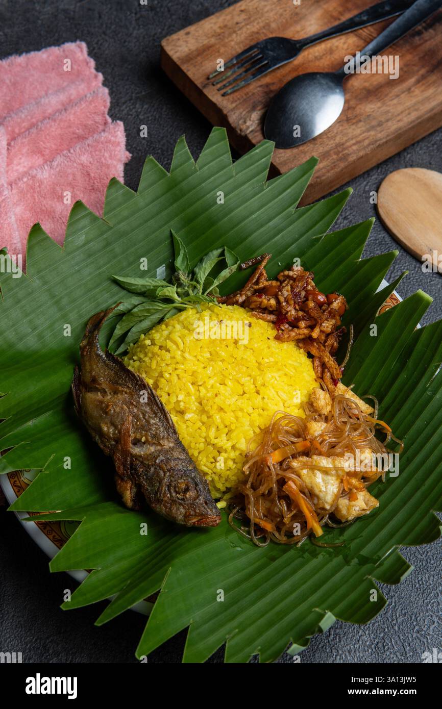 Authentic Indonesian Nasi Kuning served on banana leaves with fried ...