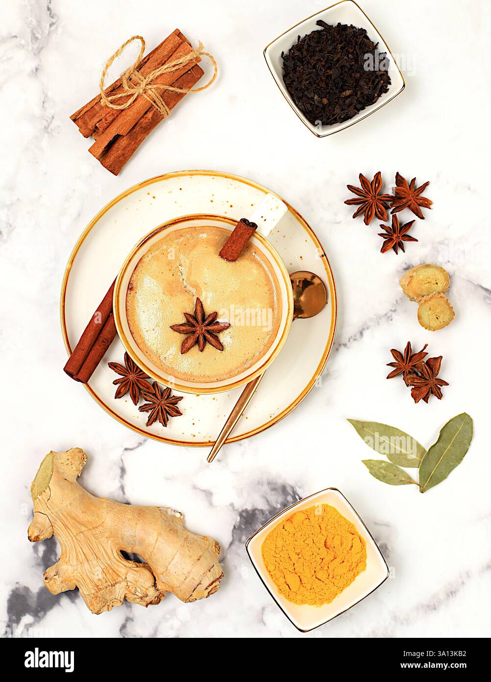 Indian masala chai tea with milk, ginger, anise and cinnamon on an old ...