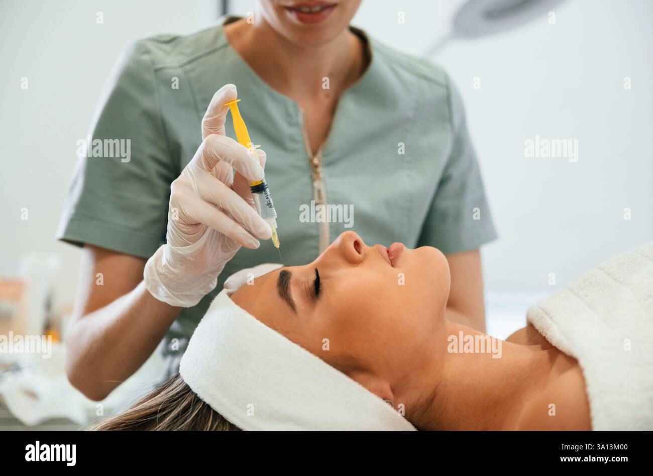 View from the side. Making injection. Woman face getting facial care by ...