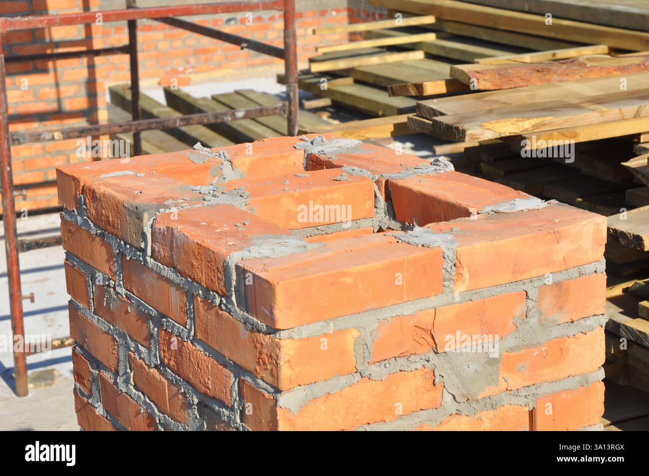 Building a brick chimney from red brick.Close up Stock Photo - Alamy
