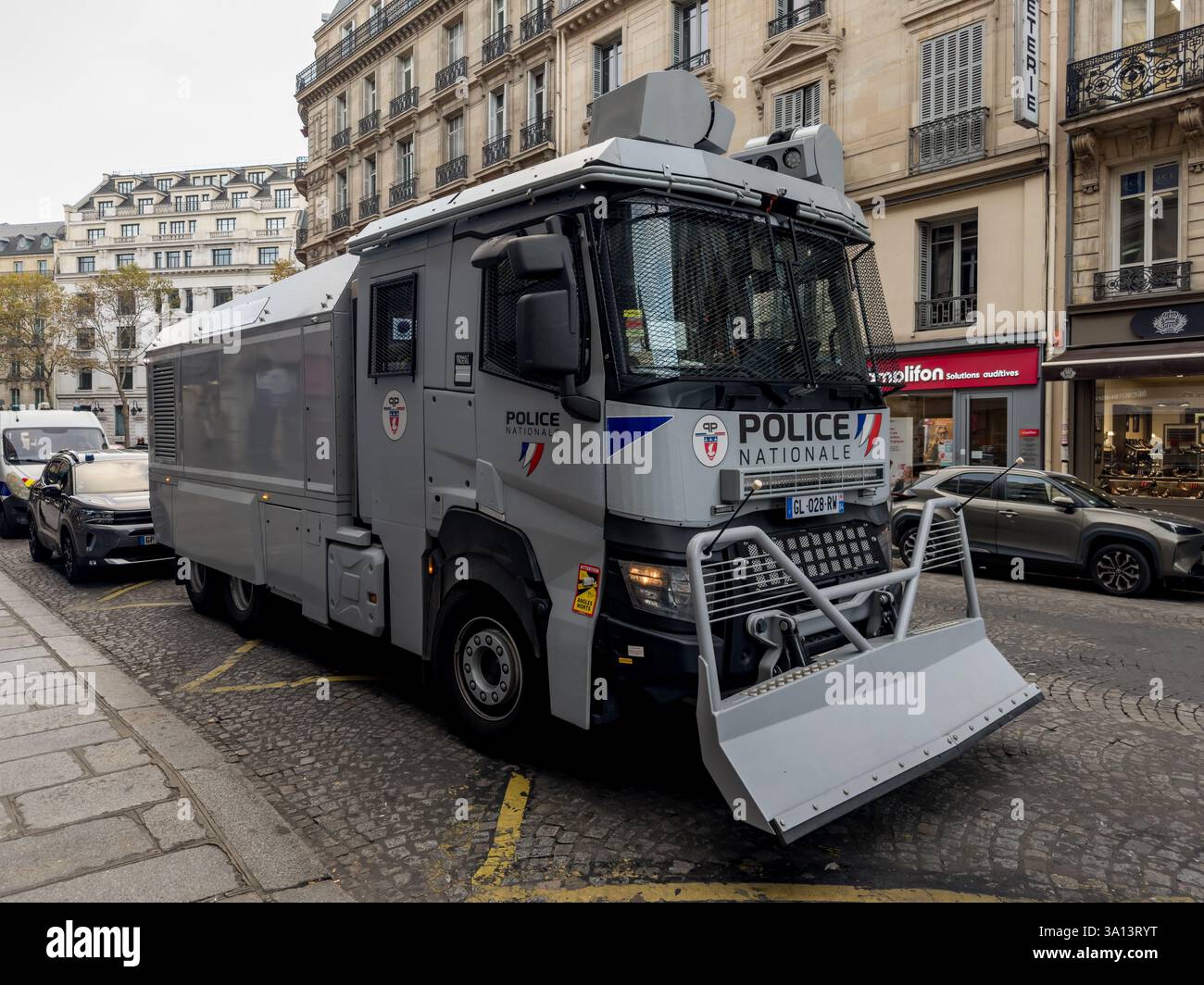 Heavy police vehicle stands ready on bustling Paris street amidst urban ...