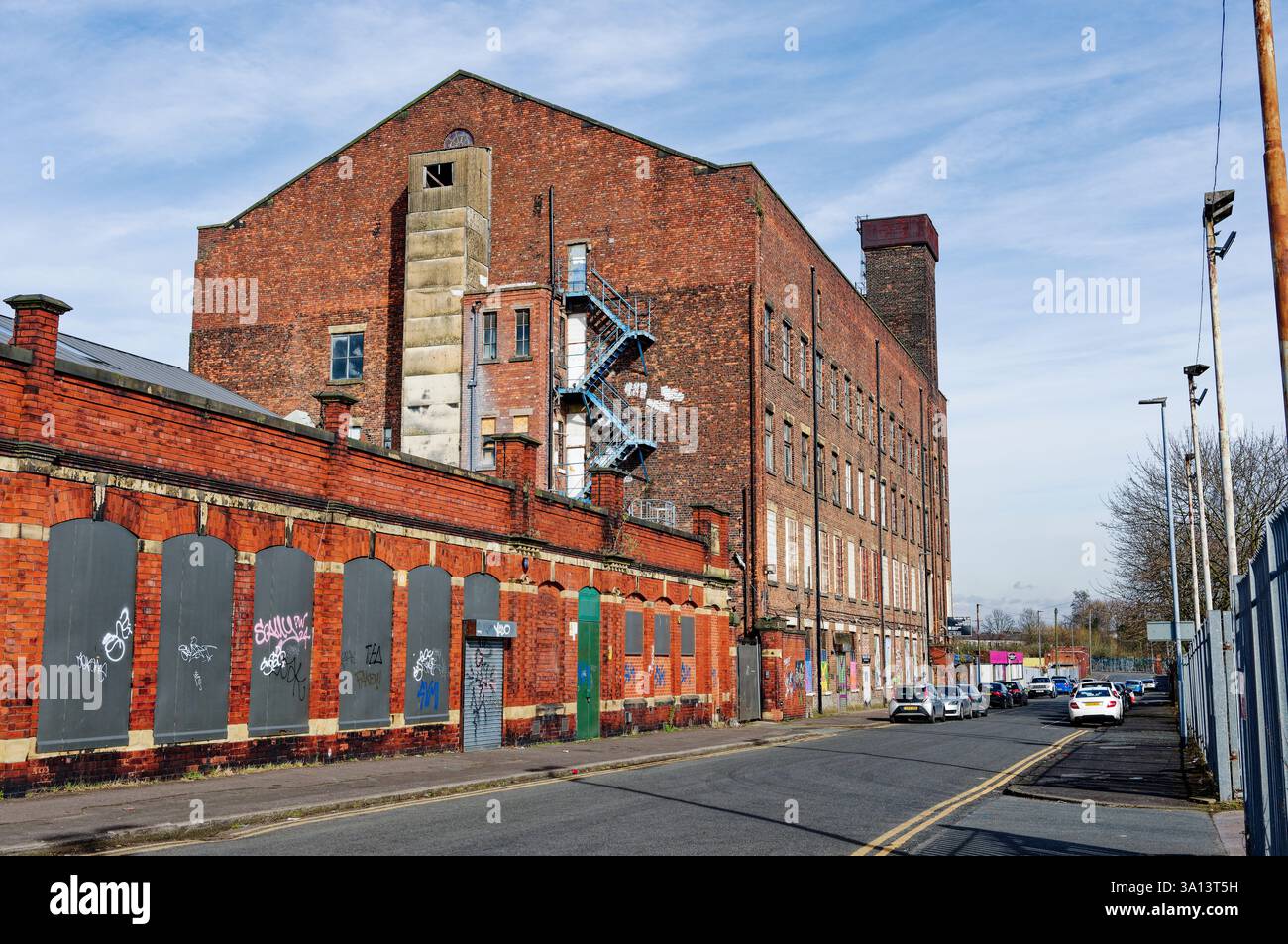 Manchester, UK, 03-01-2025: Tall brick mill building with a blue fire ...