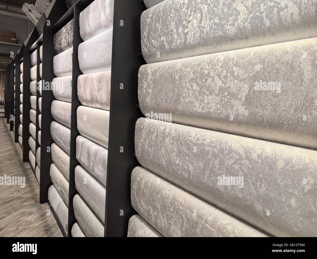 Rows of beautifully designed wallpaper rolls adorn the walls of a chic ...