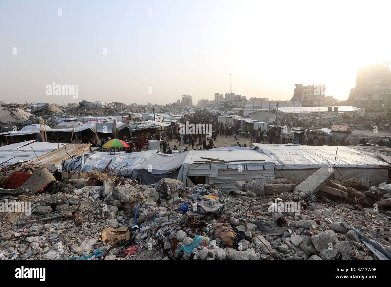 Palestinians shop at a market set up among the rubble in Jabalia ...