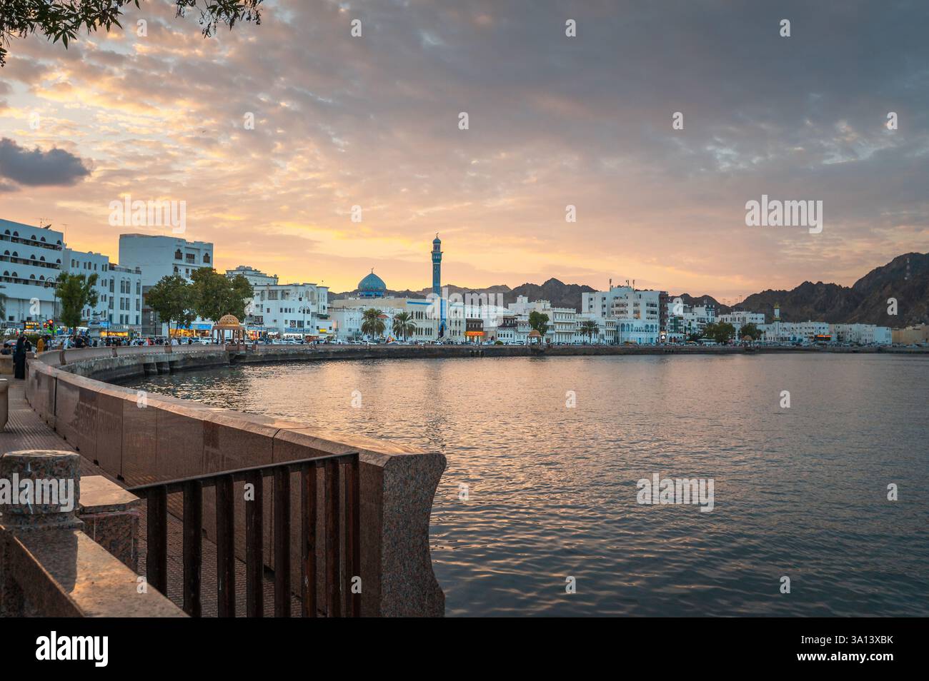 Sunset casts golden hues over Muttrah Corniche in Muscat, Oman, where ...