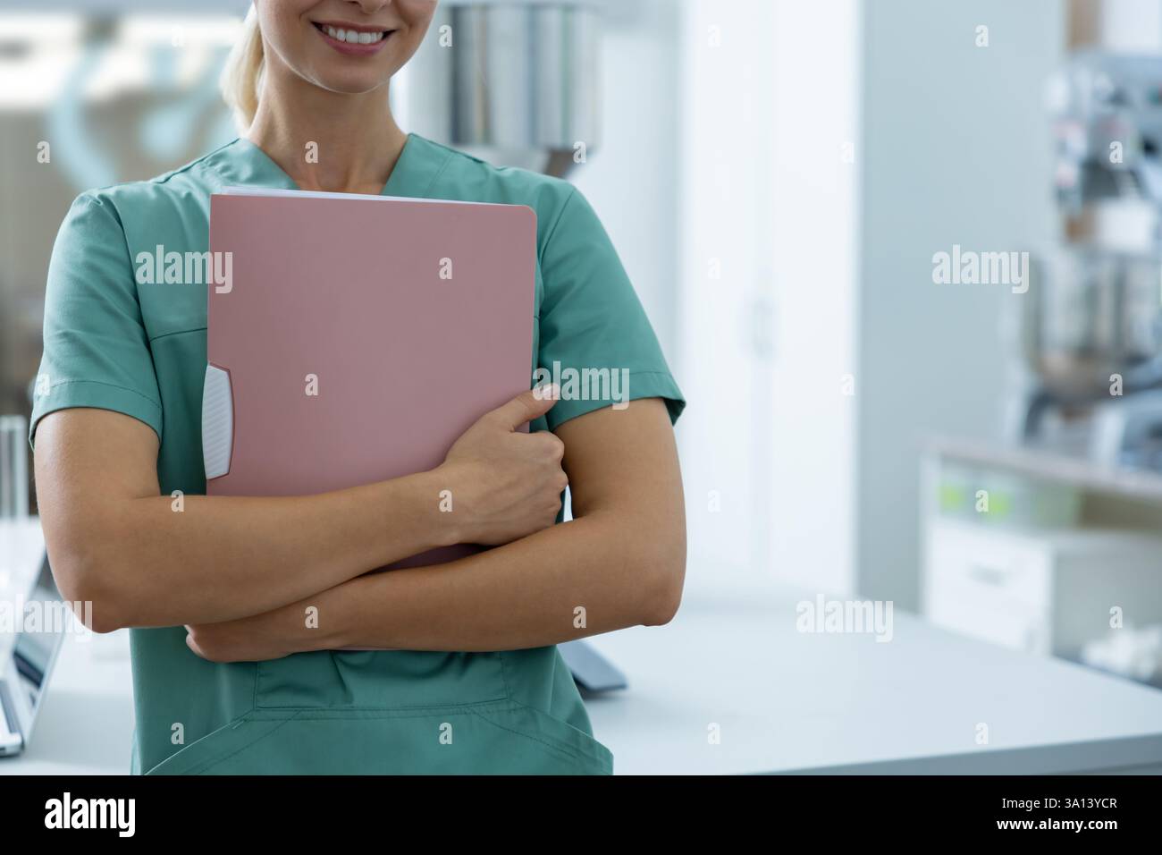 Woman scientist standing in hospital laboratory with paper folder in ...