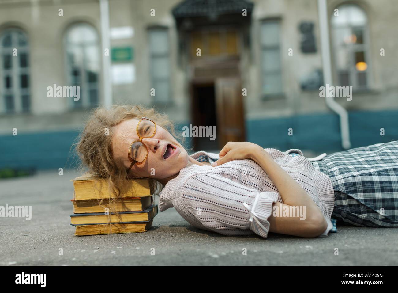 Nerdy young woman in oversized glasses struggles to carry heavy books ...