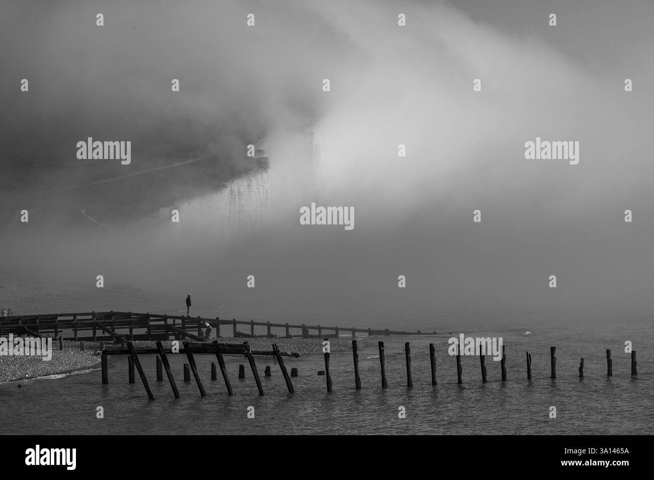 Fog rolling in over the Seven Sisters, with wooden groyne structures in ...