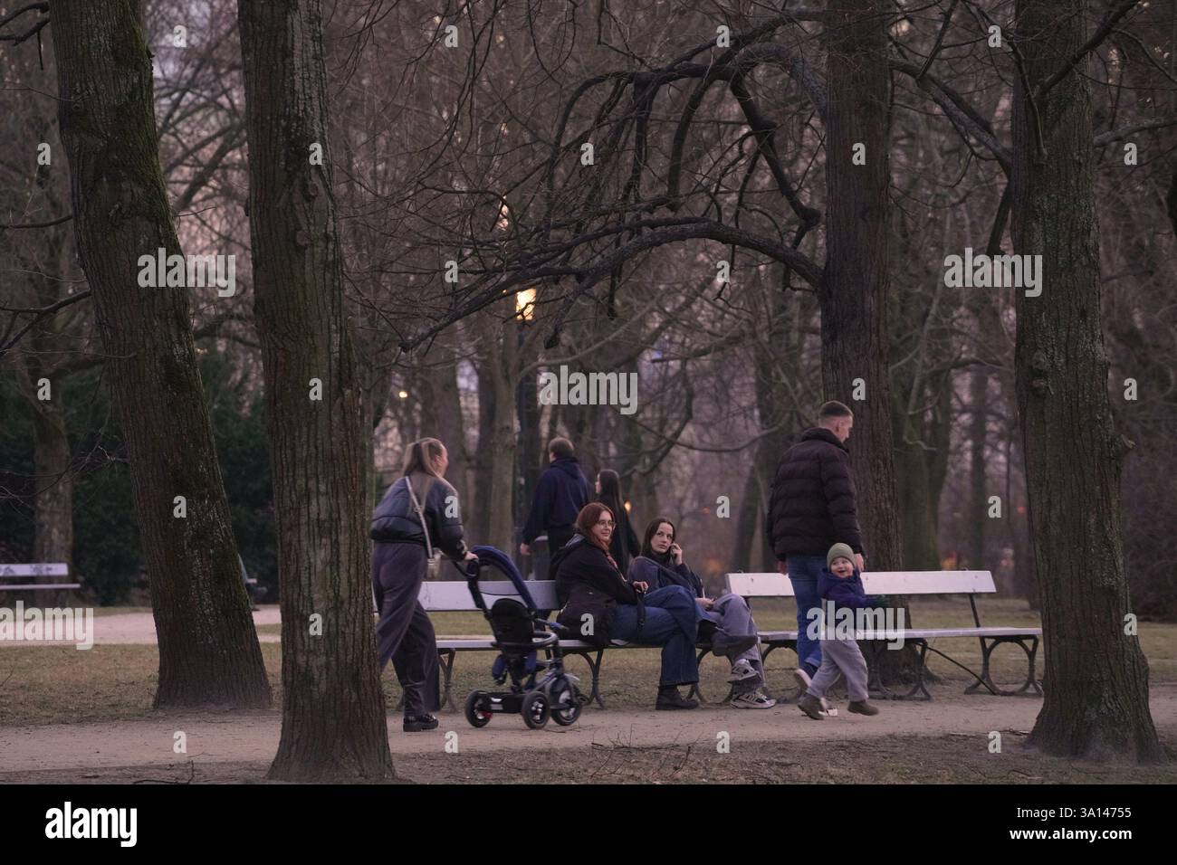 People watch as a woman with a baby stroller walks past in the Saxon ...