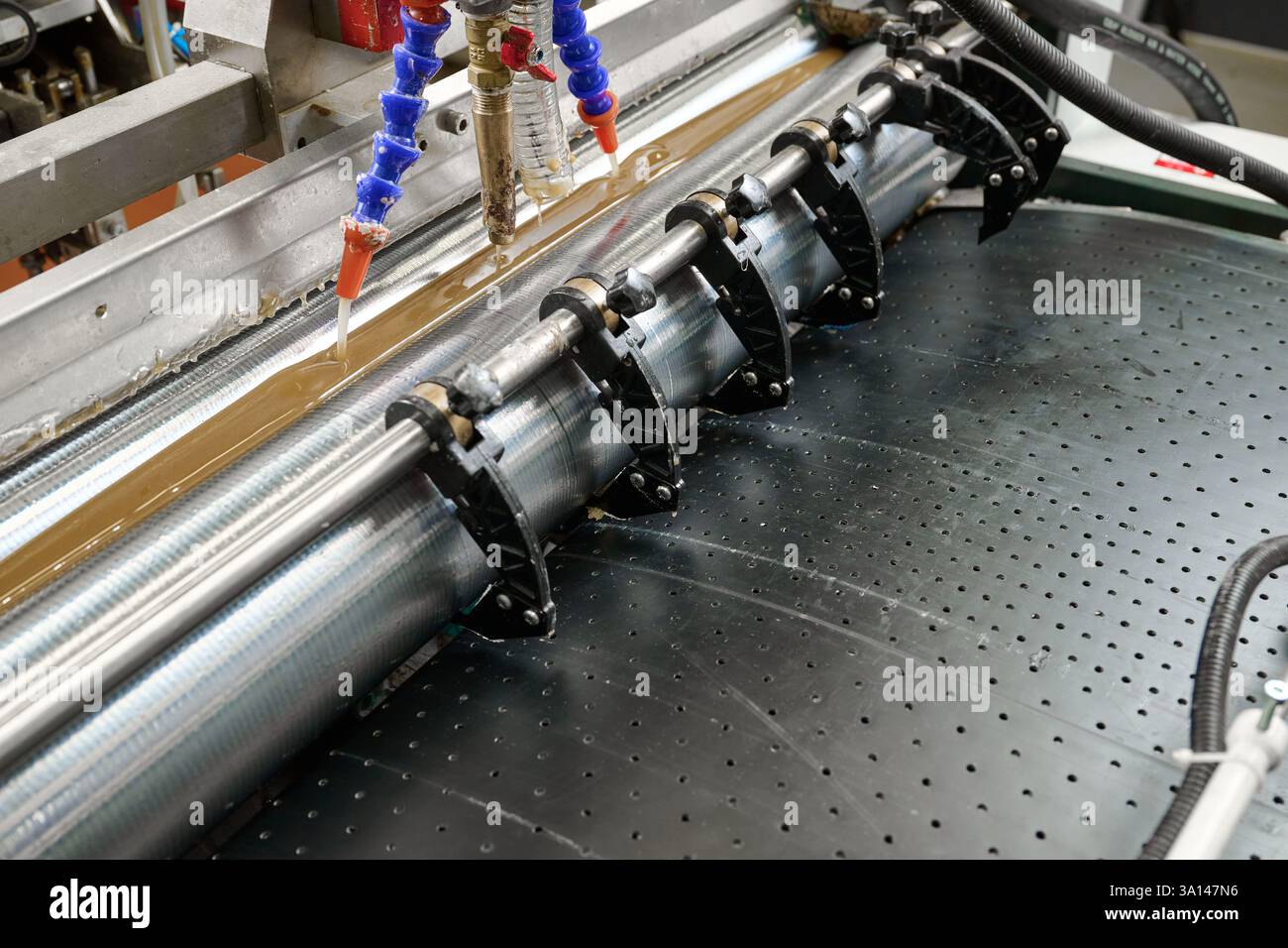 Innovative glue applicator in action at a manufacturing facility during ...