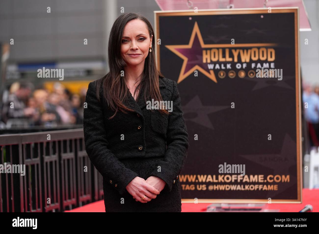 Christina Ricci poses atop her new star at a ceremony on the Hollywood ...