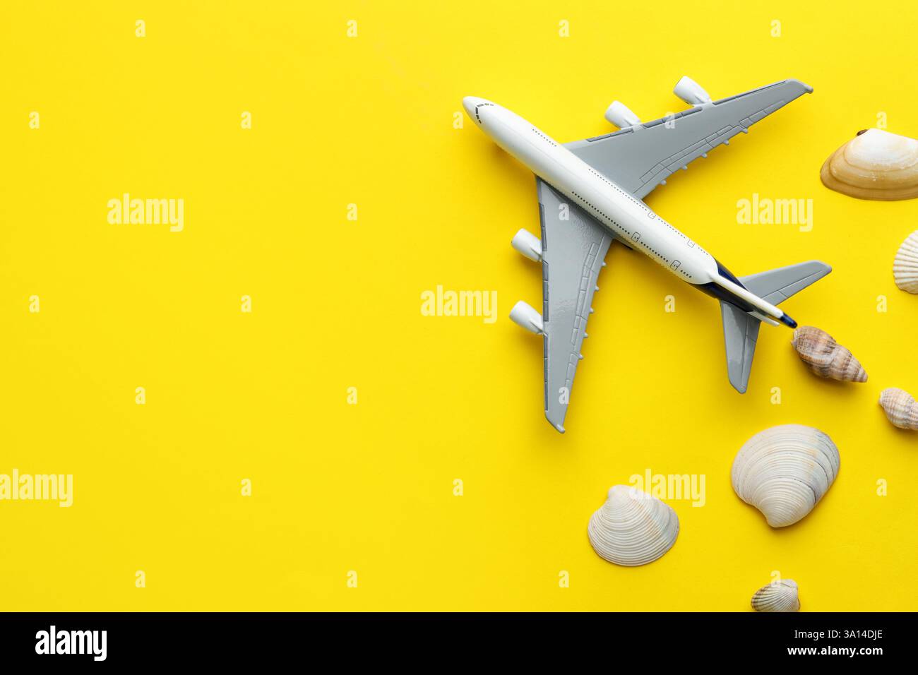 Plane model and shells on yellow background, flat lay. Space for text ...