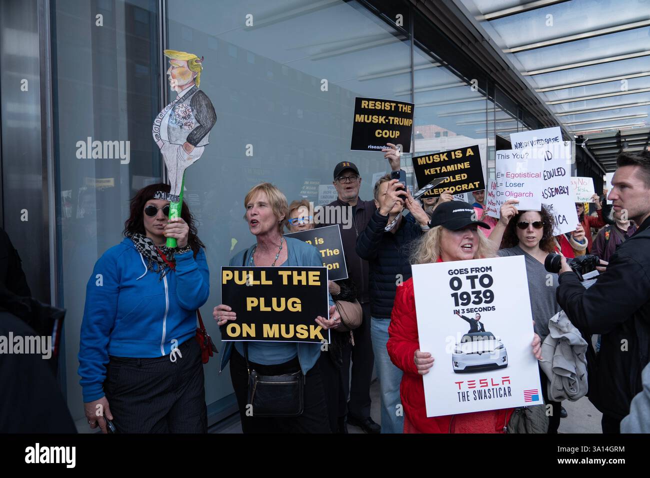 Protestors outside a Tesla Dealer in New York City expressing their ...