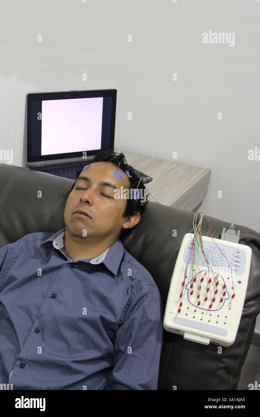 Electroencephalogram EEG in adult Latino man with wires in his head ...