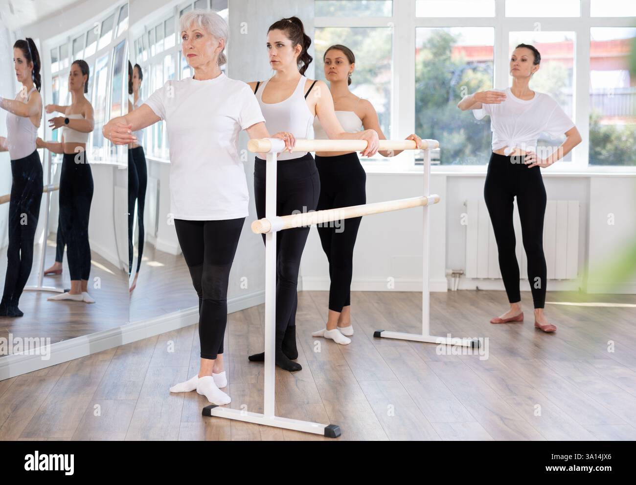 Teacher conducts class with girls in ballet studio, observes doing ...