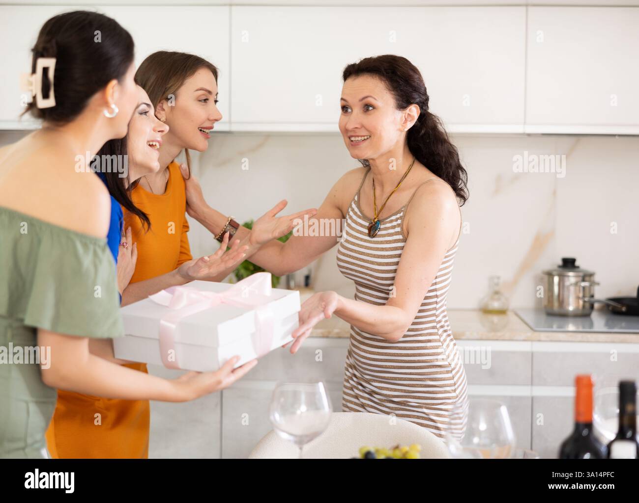 Group of women greeting each other and giving gift Stock Photo - Alamy