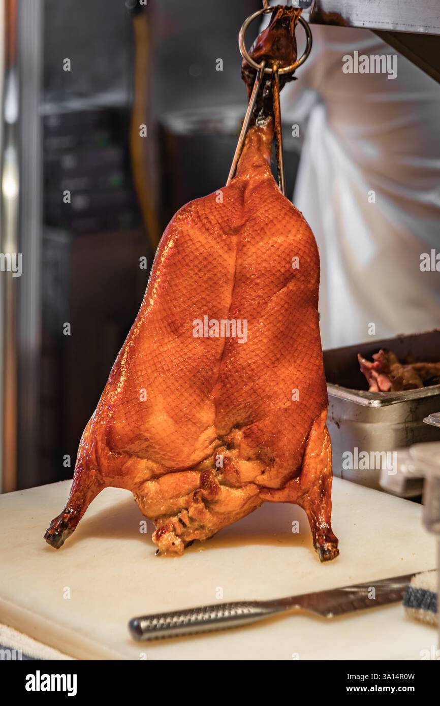 Traditional Chinese whole roasted Peking duck hanging on roasting hooks ...