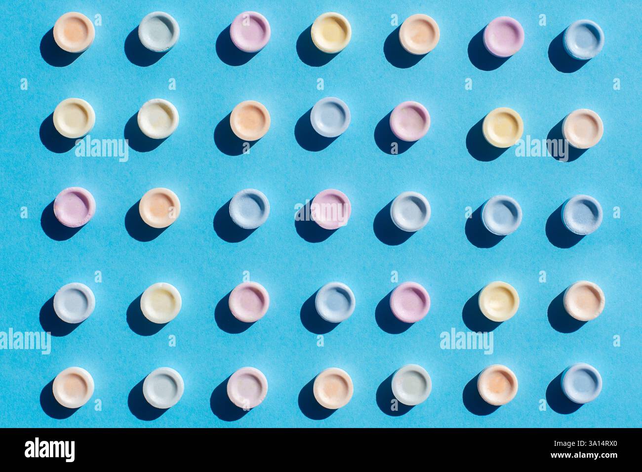 Top view of edible tablets of different colors. Sugar tablets on blue ...