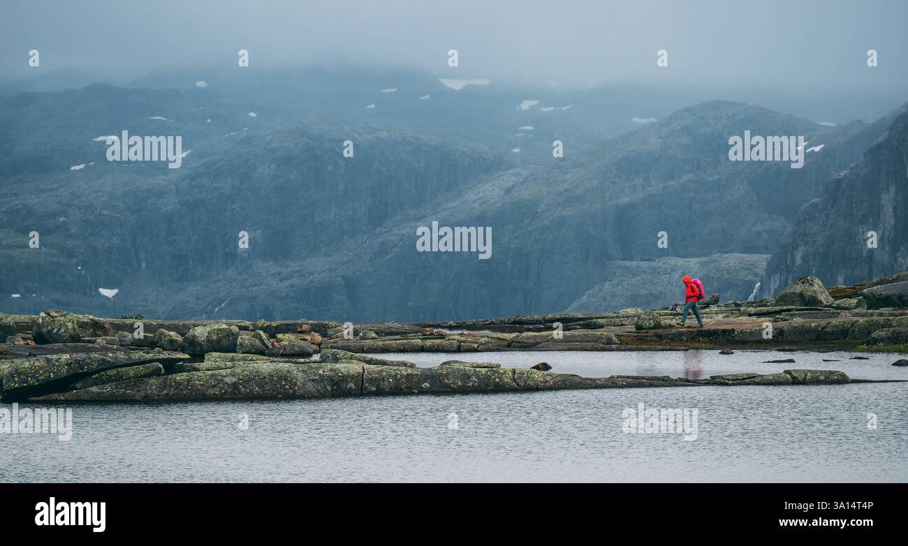 Woman trekker with backpack dressed bright red jacket enjoying famous ...