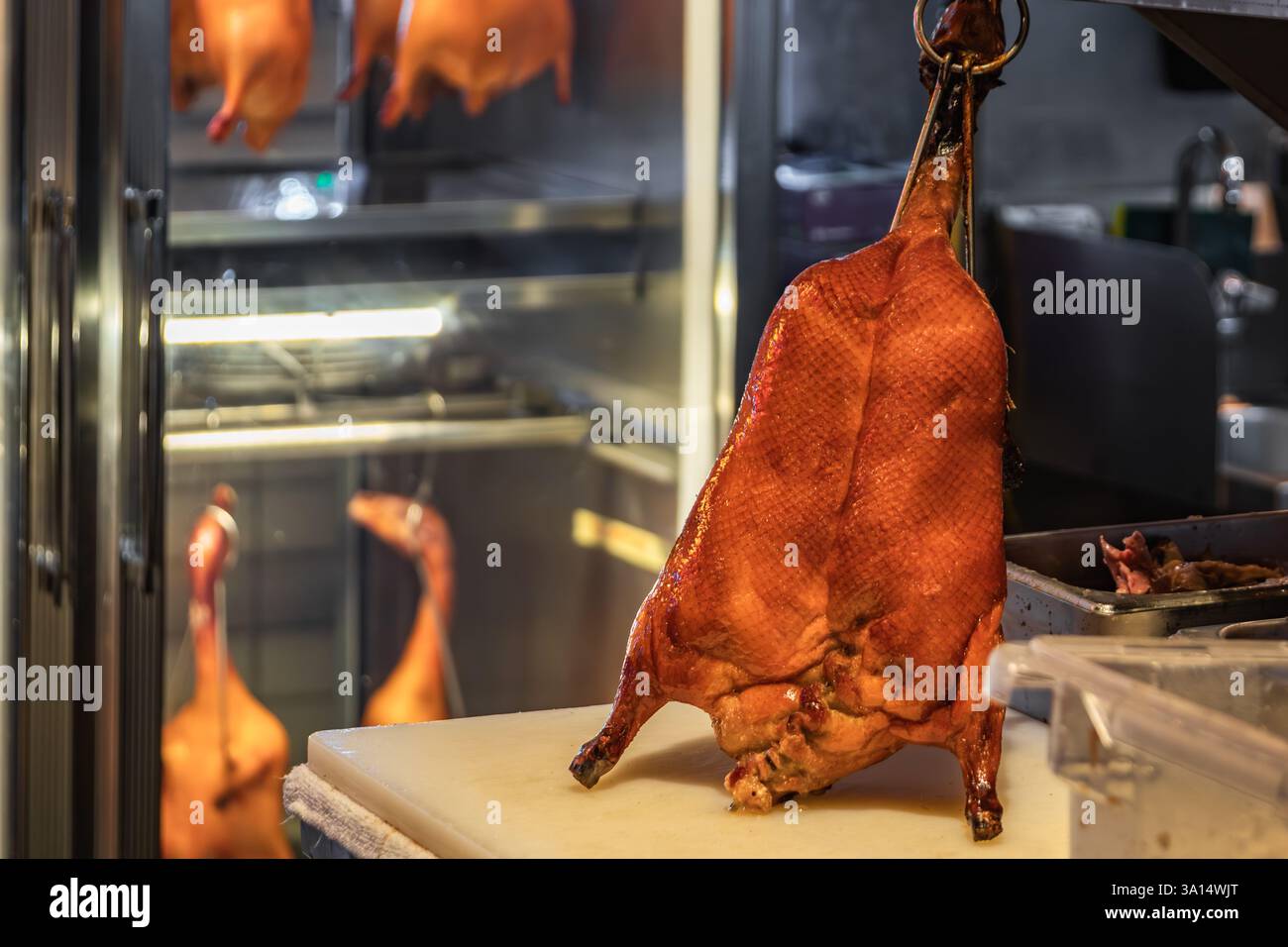 Traditional Chinese whole roasted Peking duck hanging on roasting hooks ...