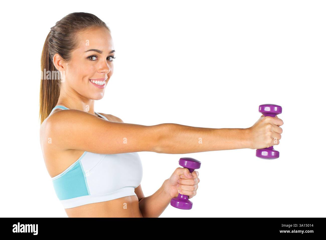 A beautiful brunette fitness model poses confidently in a studio ...