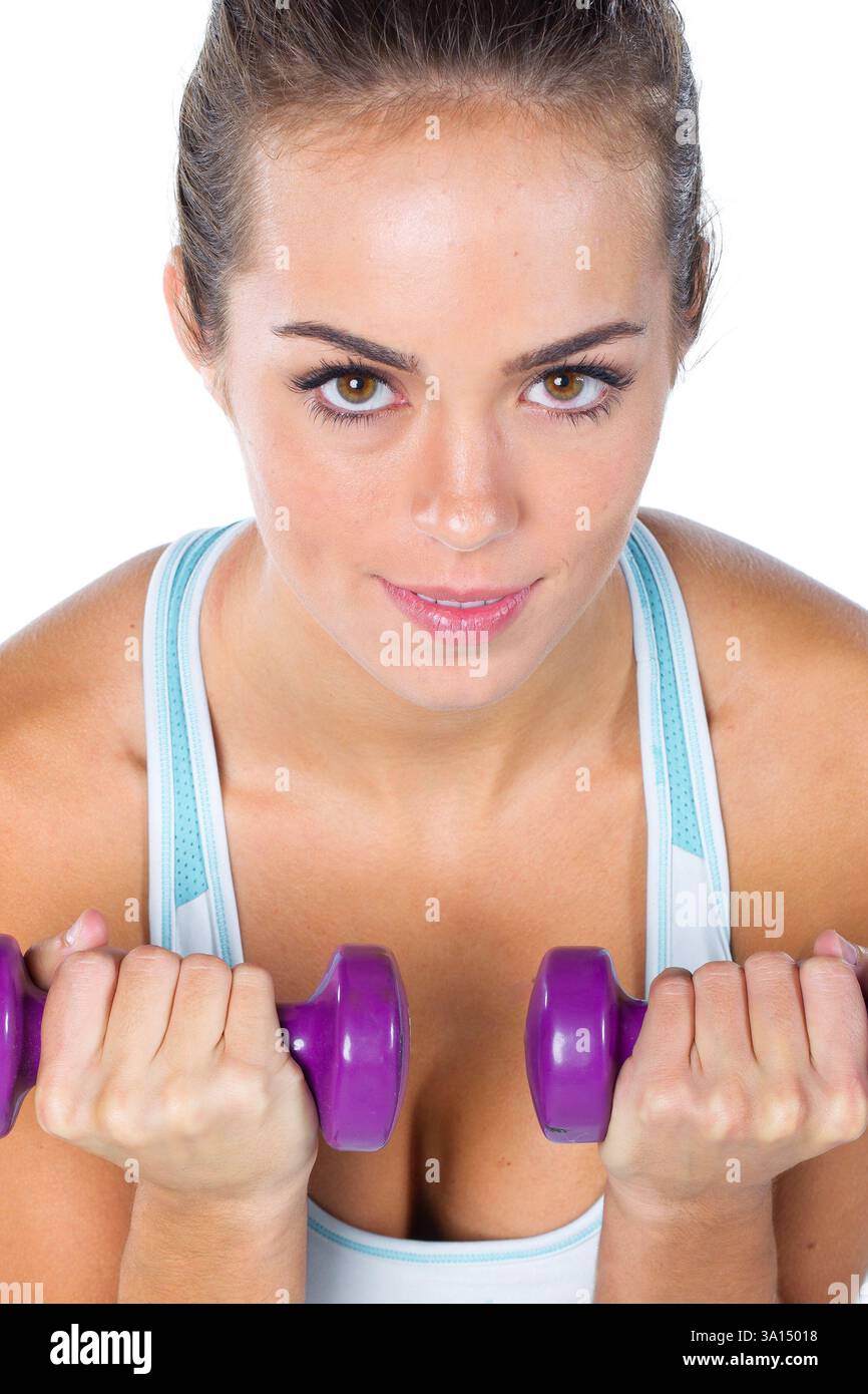 A beautiful brunette fitness model poses confidently in a studio, showcasing her toned muscles ...