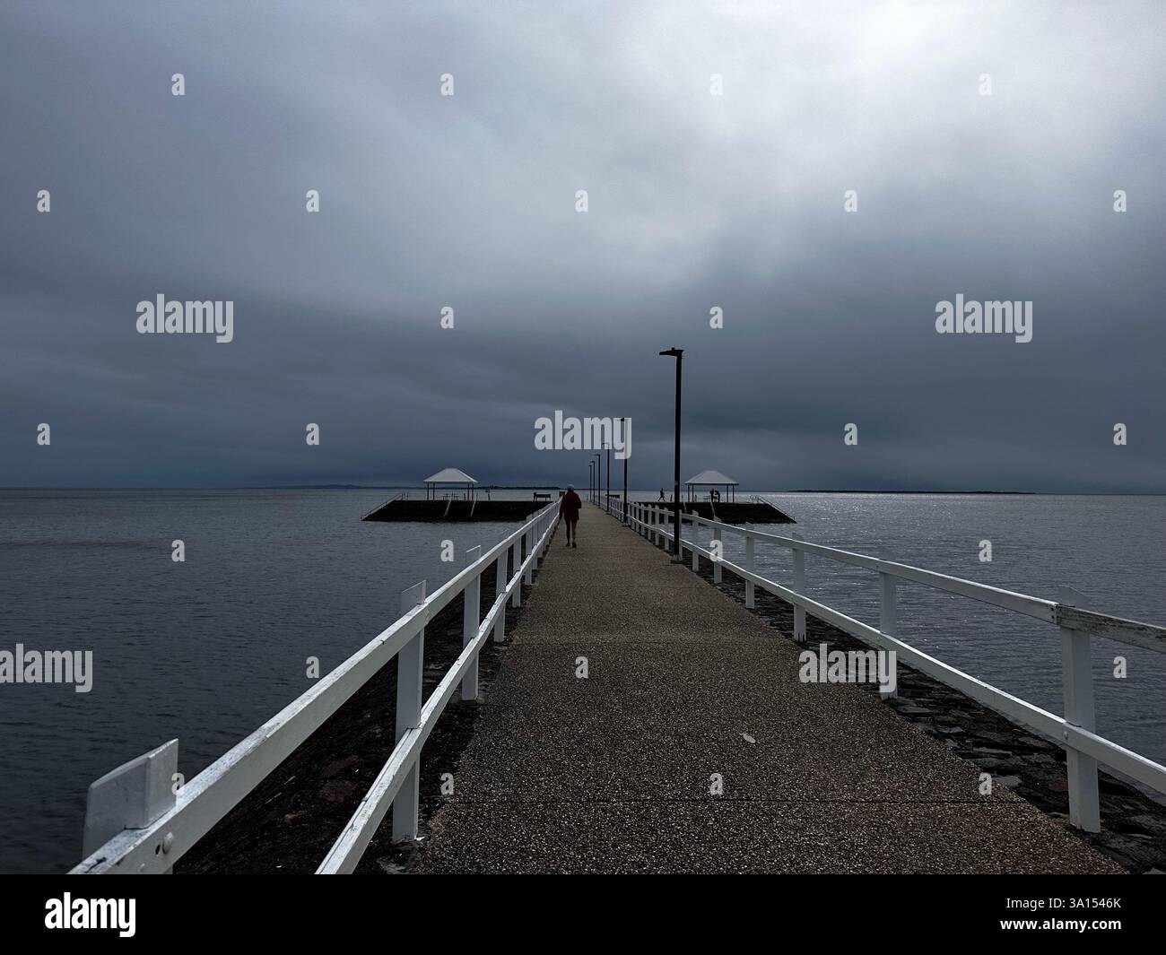 People walking along Wynnum foreshore ahead of the cyclone in Brisbane ...