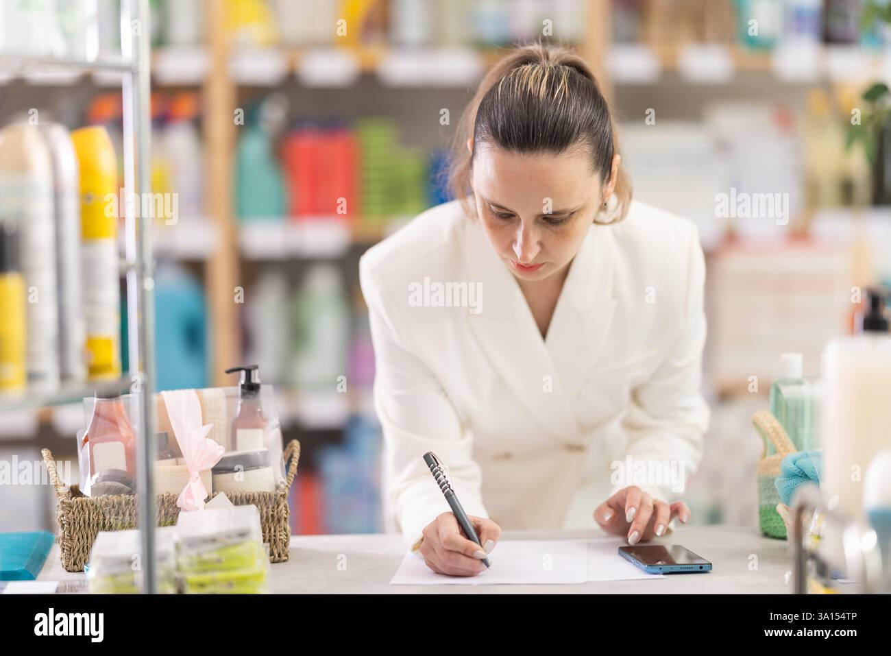 Adult woman conducting inventory with checklist and phone Stock Photo ...