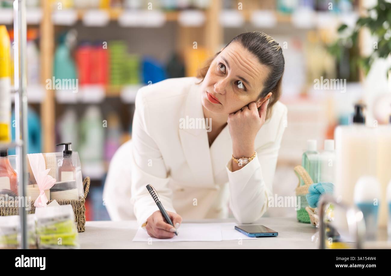 Adult woman conducting inventory with checklist and phone Stock Photo ...