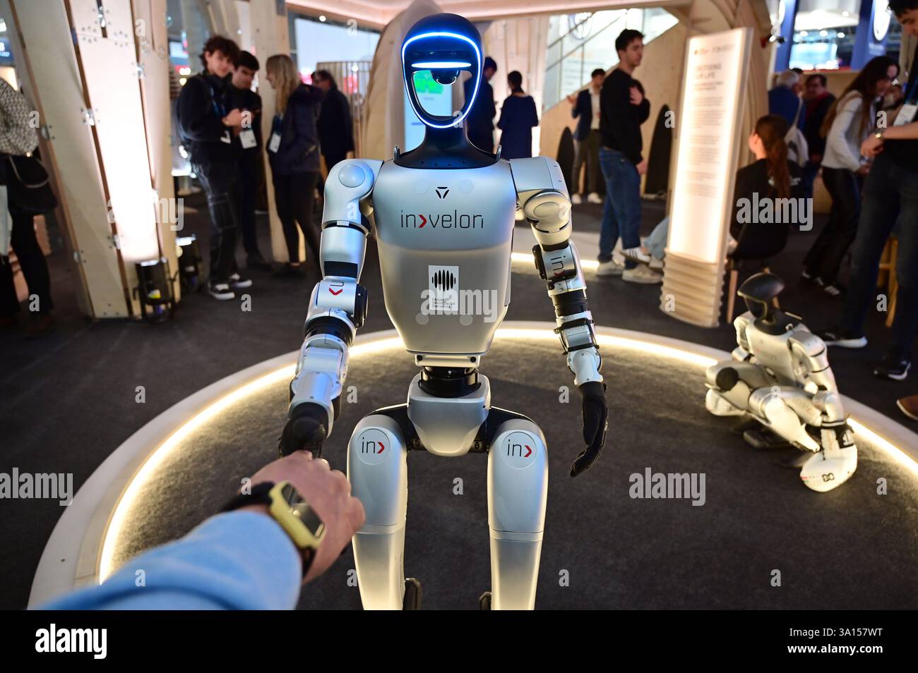 A man greets the robot of the Invelon Robotics brand during the Mobile ...