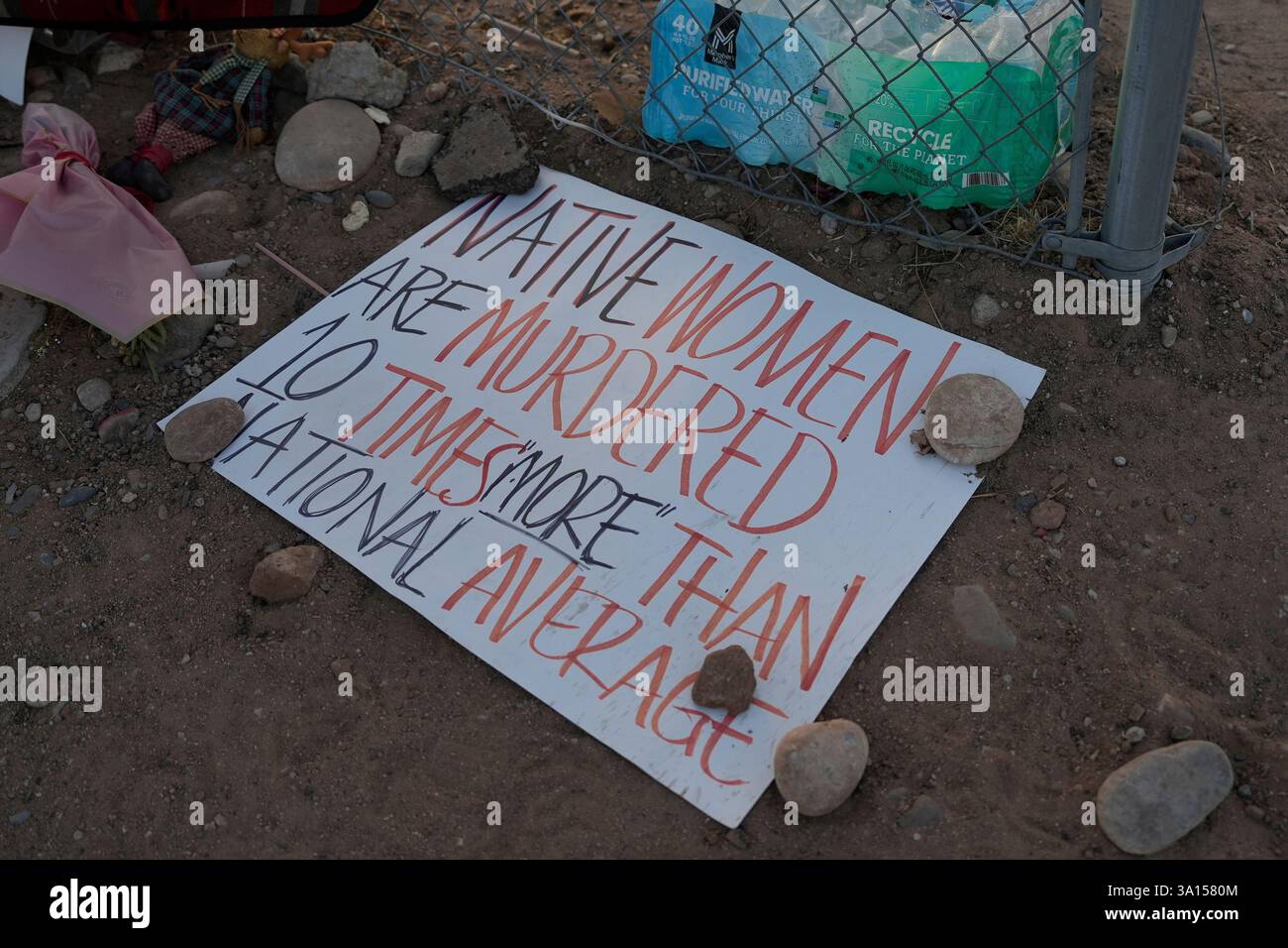A sign lies on the ground at a vigil for slain Native American teen ...