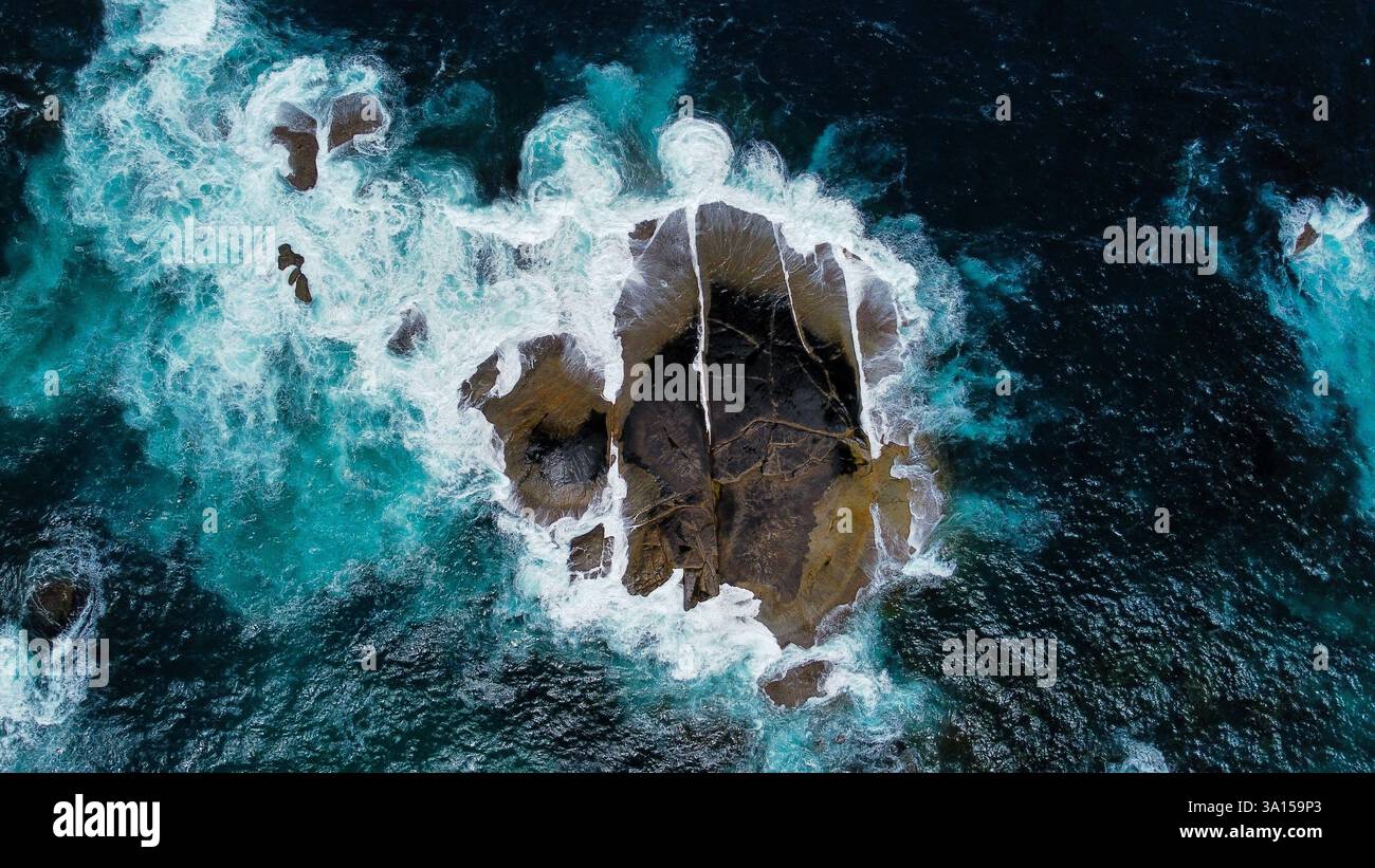 Beautiful oceanic offshore rock island with waves crashing over it ...