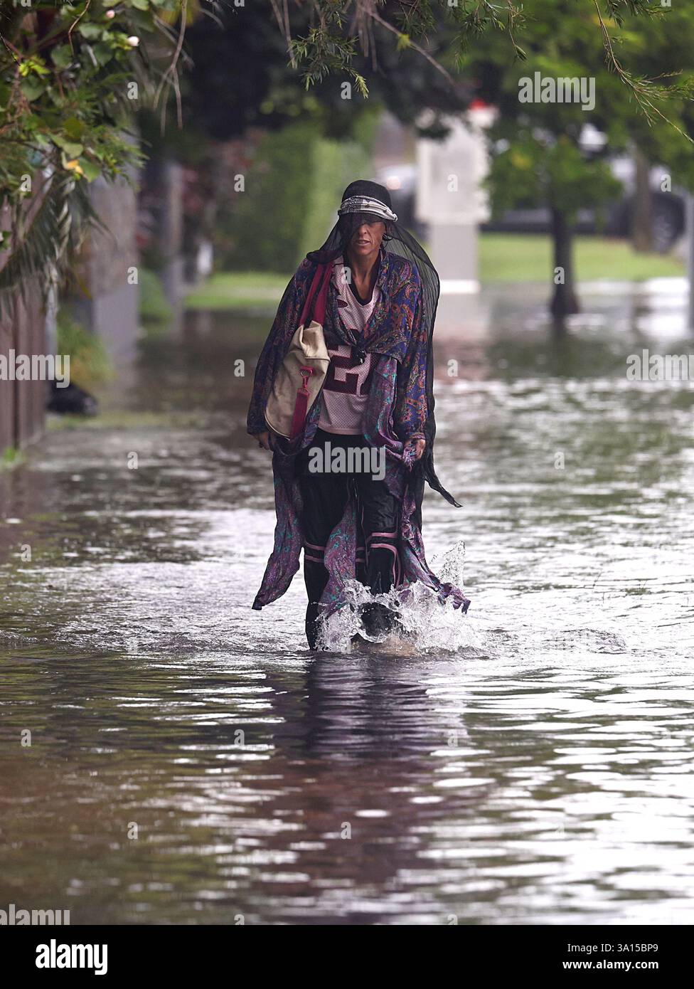 A person walks on a flooded Ewingsdale road in Byron Bay March 7, 2025 ...