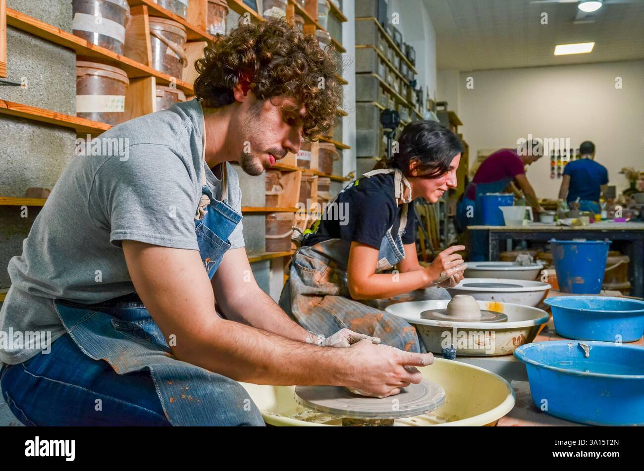 Craftsmen shaping clay on pottery wheels in a ceramics workshop Stock Photo - Alamy