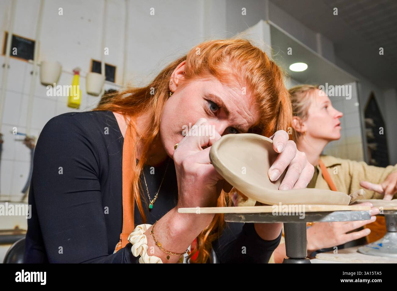Craftswoman smoothing clay bowl in pottery studio, creating handmade ...