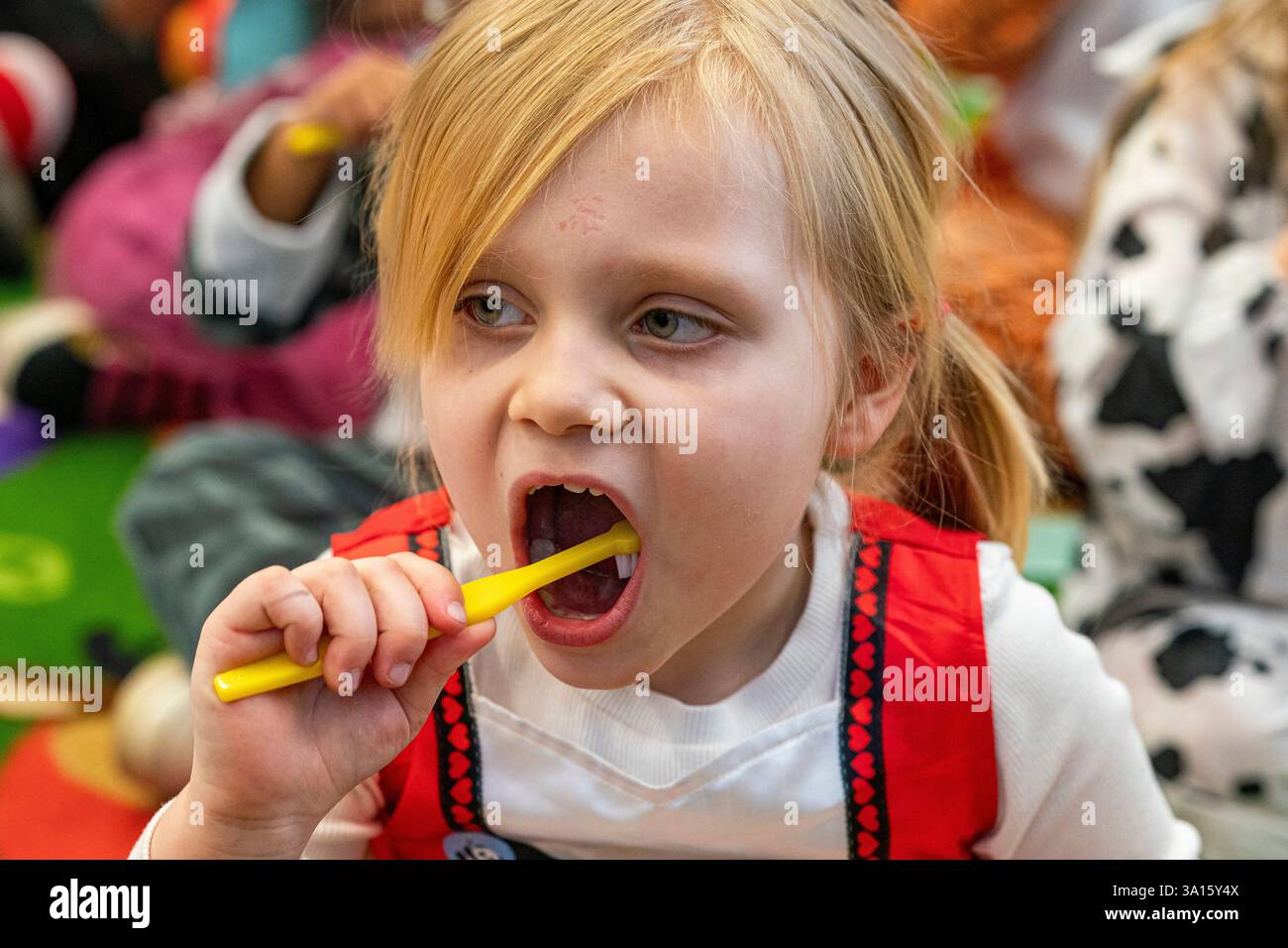 School children brush their teeth for two minutes inside a classroom at ...