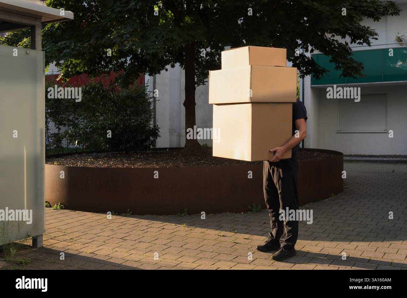 Delivery man holds the big boxes Stock Photo - Alamy