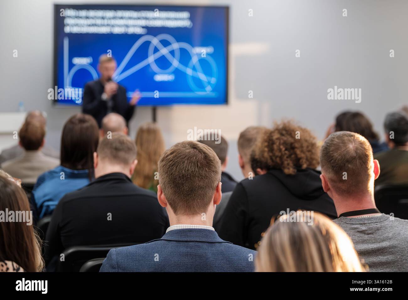 Business professional delivering presentation to engaged audience with ...