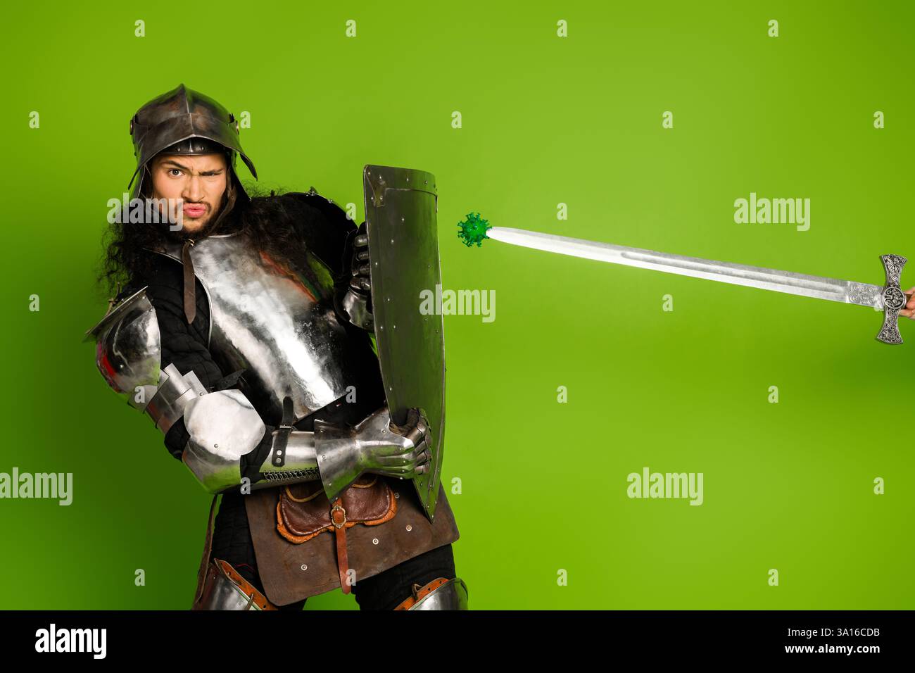 Knight in metallic armor holds a shield against a sword in front of ...