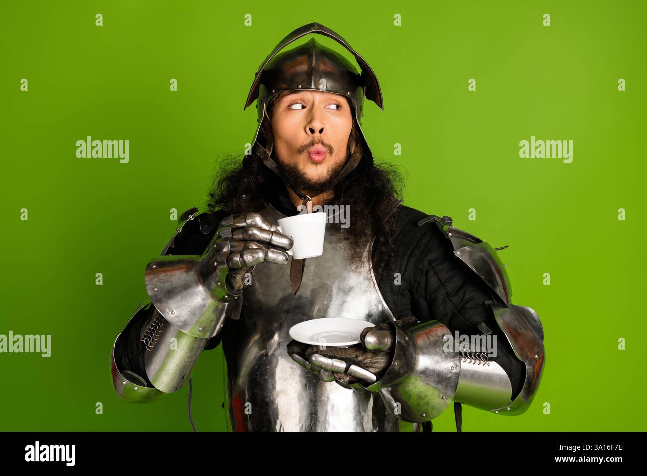 Young man in detailed medieval knight armor drinking coffee with a ...